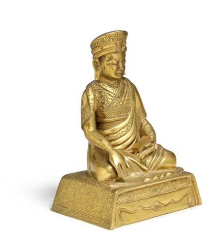 A Chinese gilt bronze figure of a Buddhist master seated on a carpeted ...
