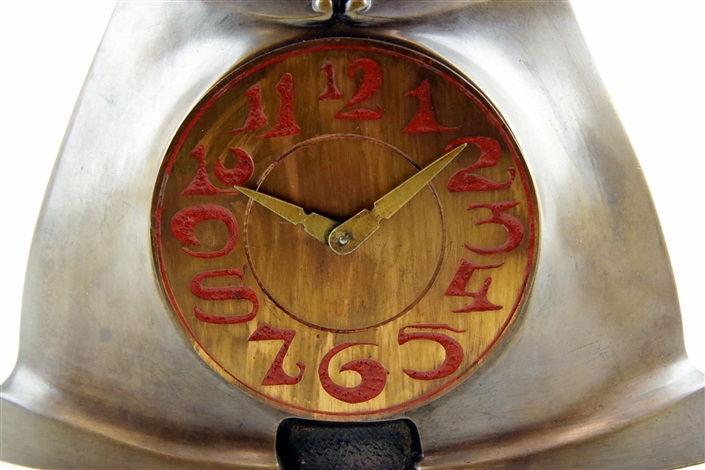 A parabola shaped bronze mantle clock with a standing female figure on ...