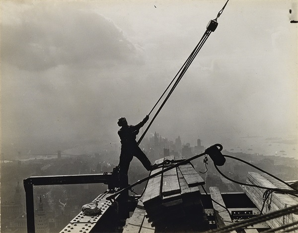 Construction worker maneuvering rope and pulley, Empire State Building ...