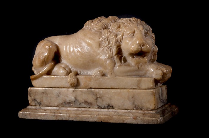 A GRAND TOUR CARVED VARIEGATED ALABASTER MODEL OF A RECUMBENT LION ...