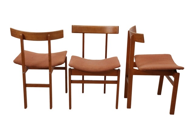 a teak dining table, with a circular table top raised over offset legs ...