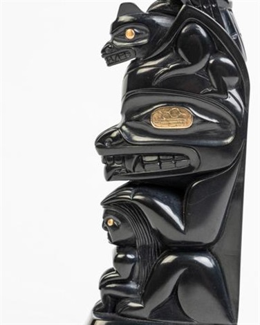 a carved argillite totem pole, depicting a Raven and Bear holding Woman ...