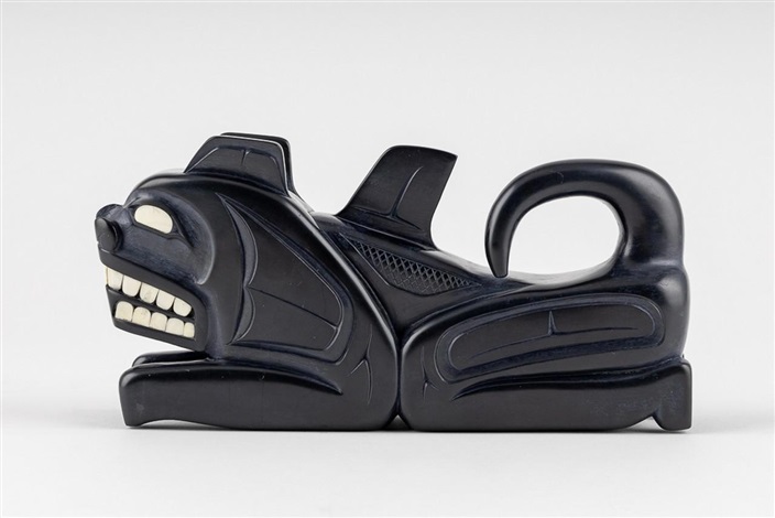 an argillite carving of Sea Wolf, inset with ivorybone eyes and teeth ...