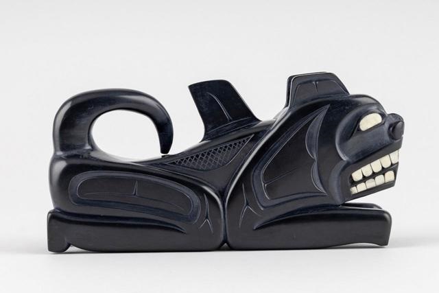an argillite carving of Sea Wolf, inset with ivorybone eyes and teeth ...