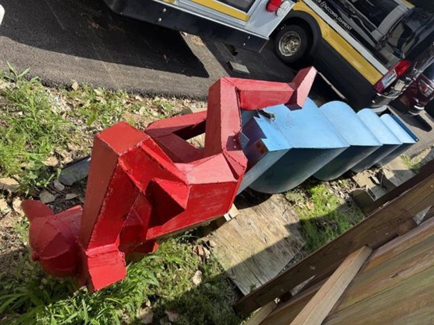 Red figure wearing a ball cap with hands behind his head, seated a top ...