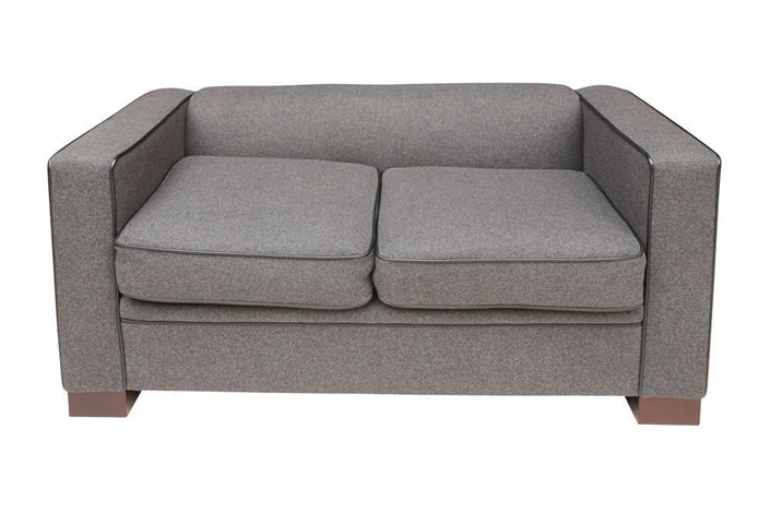 a Max sofa, upholstered in grey upholstery, with grey piping, raised on ...