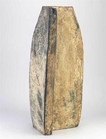 A tall angular stoneware vessel with textured surface covered in iron ...