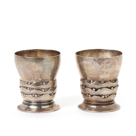 Two small silver goblets, stem with wavy relief decor with silver beads ...