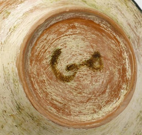 A stoneware bowl decorated with patterns in yellowish green and dark ...