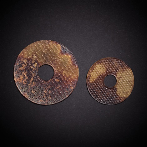 Two celadon and russet jade archaistic discs, Ming dynasty or earlier ...
